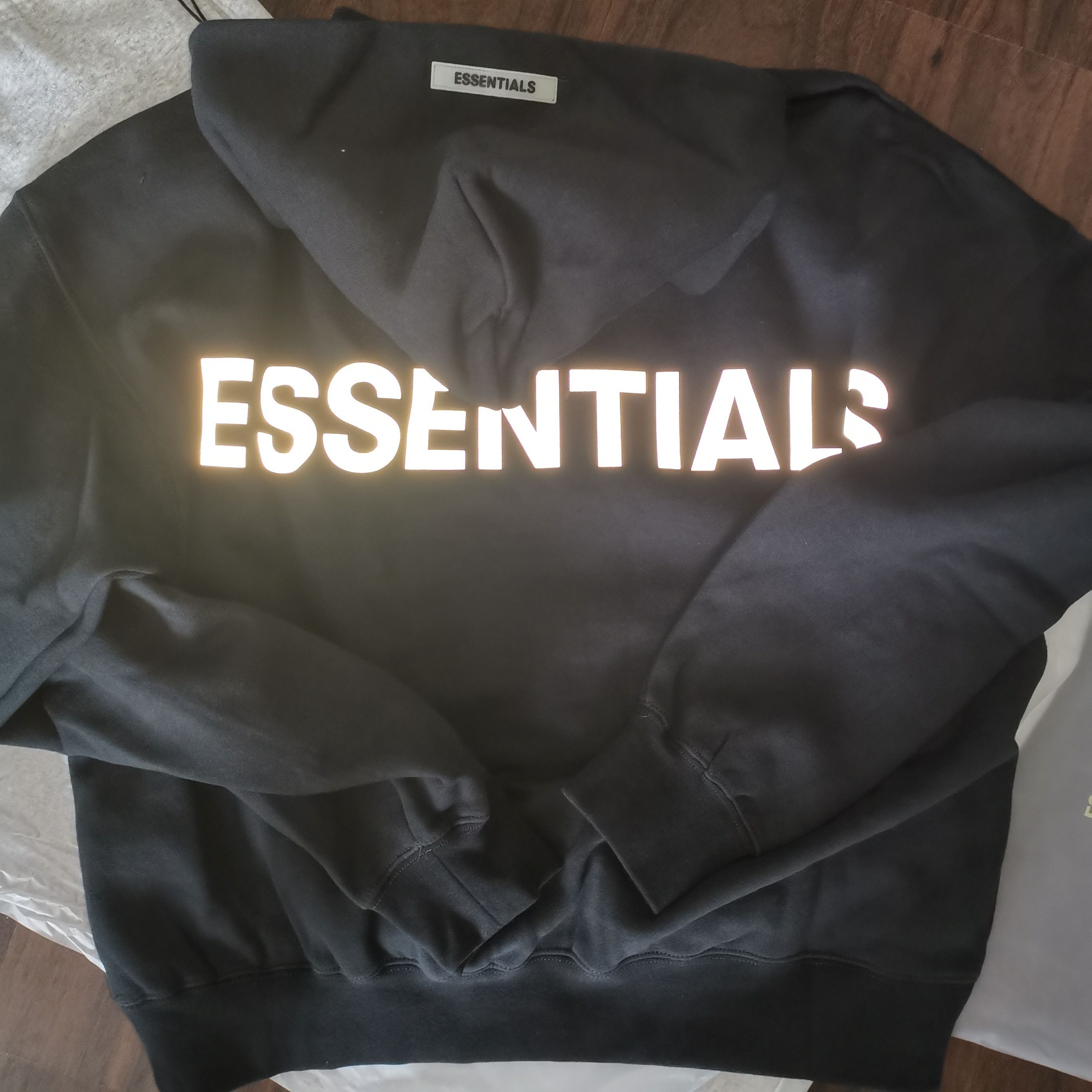 Fear of God essential black reflective hoodie | Grailed