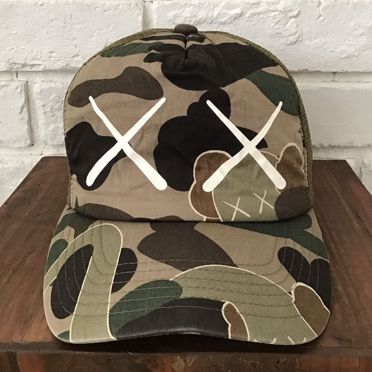 Bape BAPE × kaws bendy 1st camo green trucker hat cap nigo | Grailed