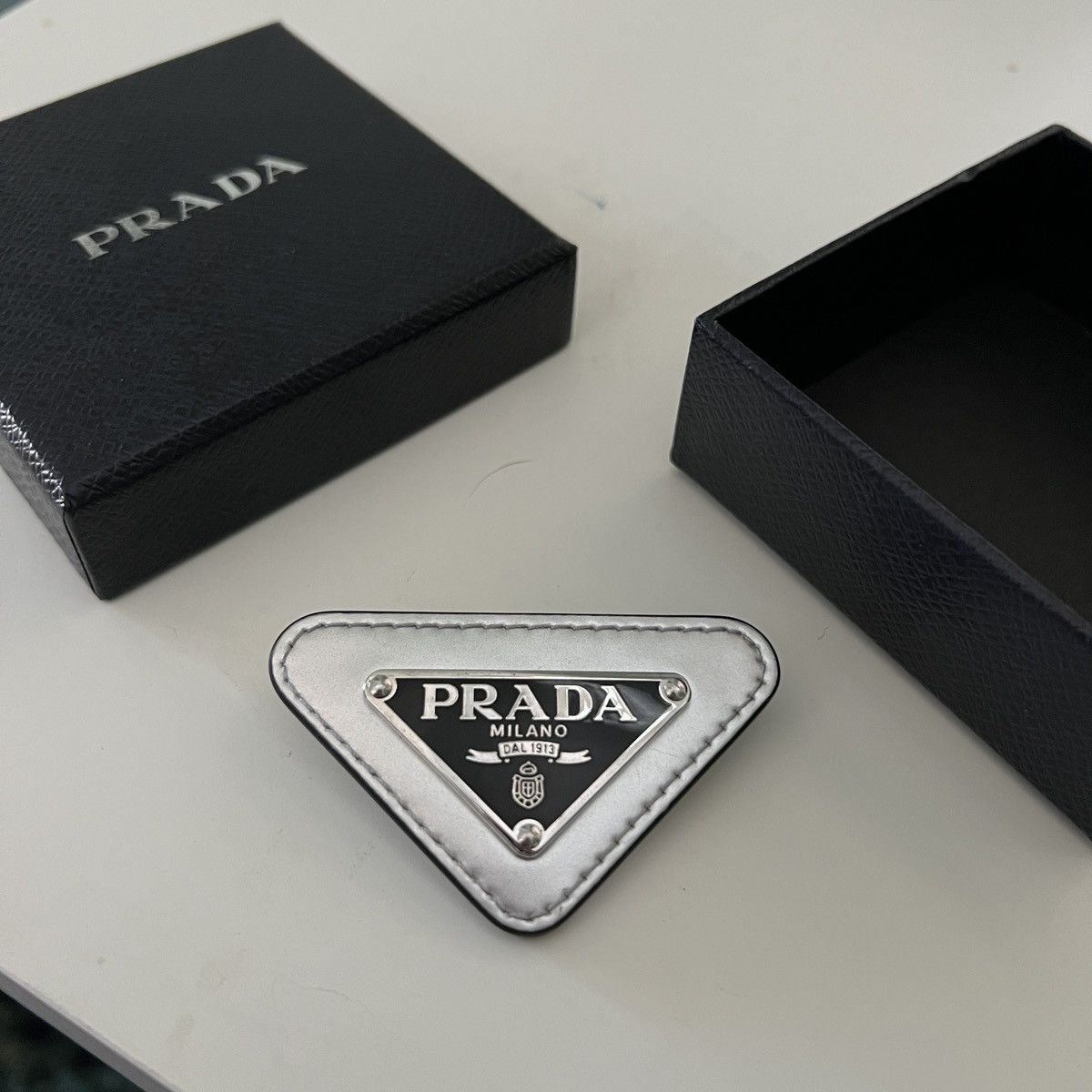 Prada Prada enamelled triangle-logo pin REALLY RARE | Grailed