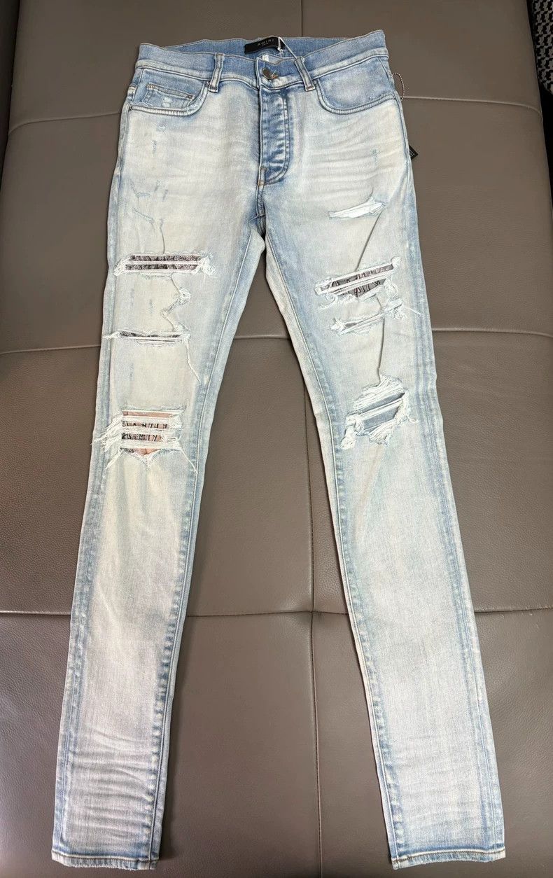 Amiri Amiri ripped patch jeans | Grailed